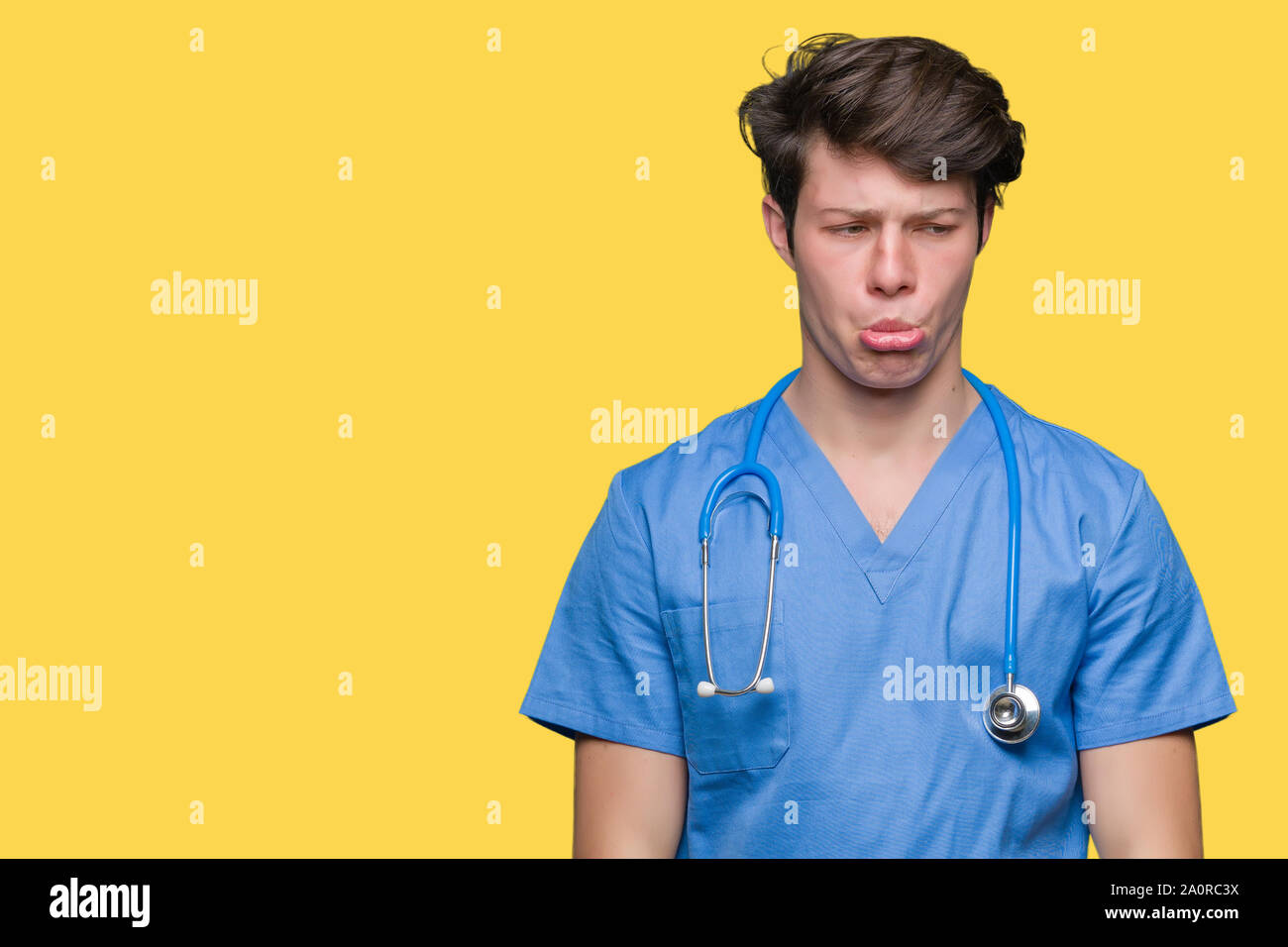 Young doctor wearing medical uniform over isolated background depressed ...