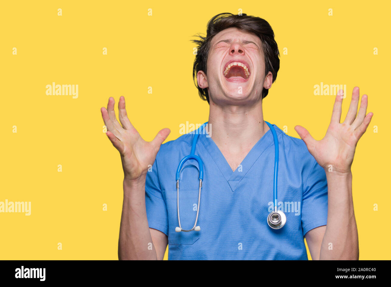 Young doctor wearing medical uniform over isolated background ...