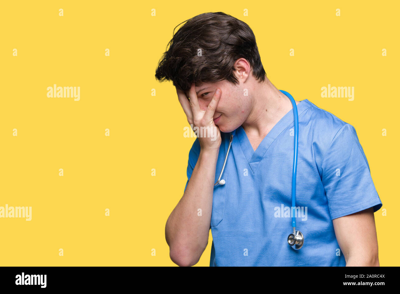 Young doctor wearing medical uniform over isolated background with sad ...