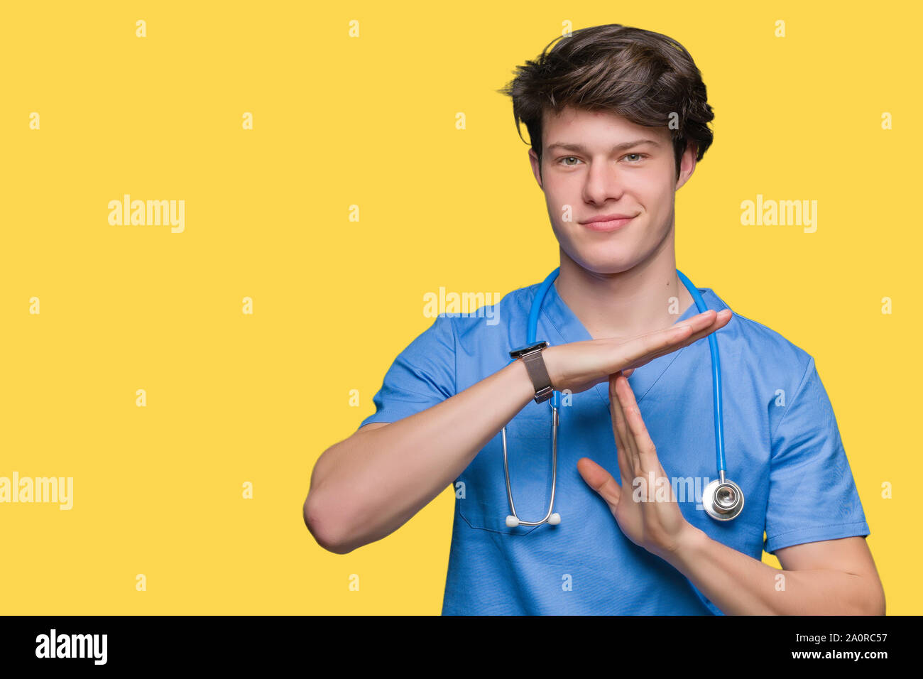 Young doctor wearing medical uniform over isolated background Doing ...