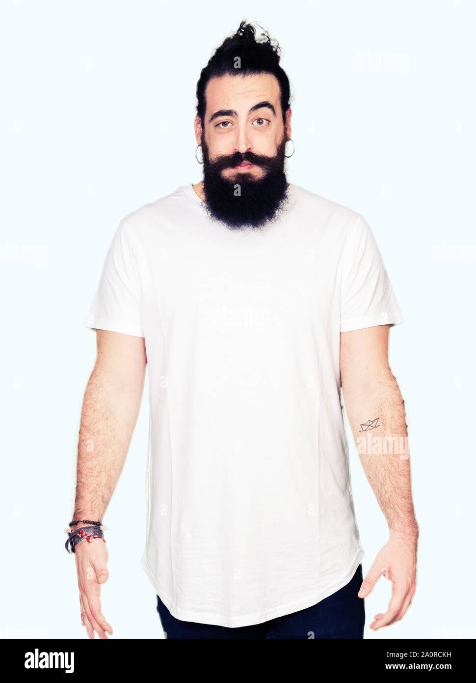 Young hipster man with long hair and beard wearing casual white t-shirt ...