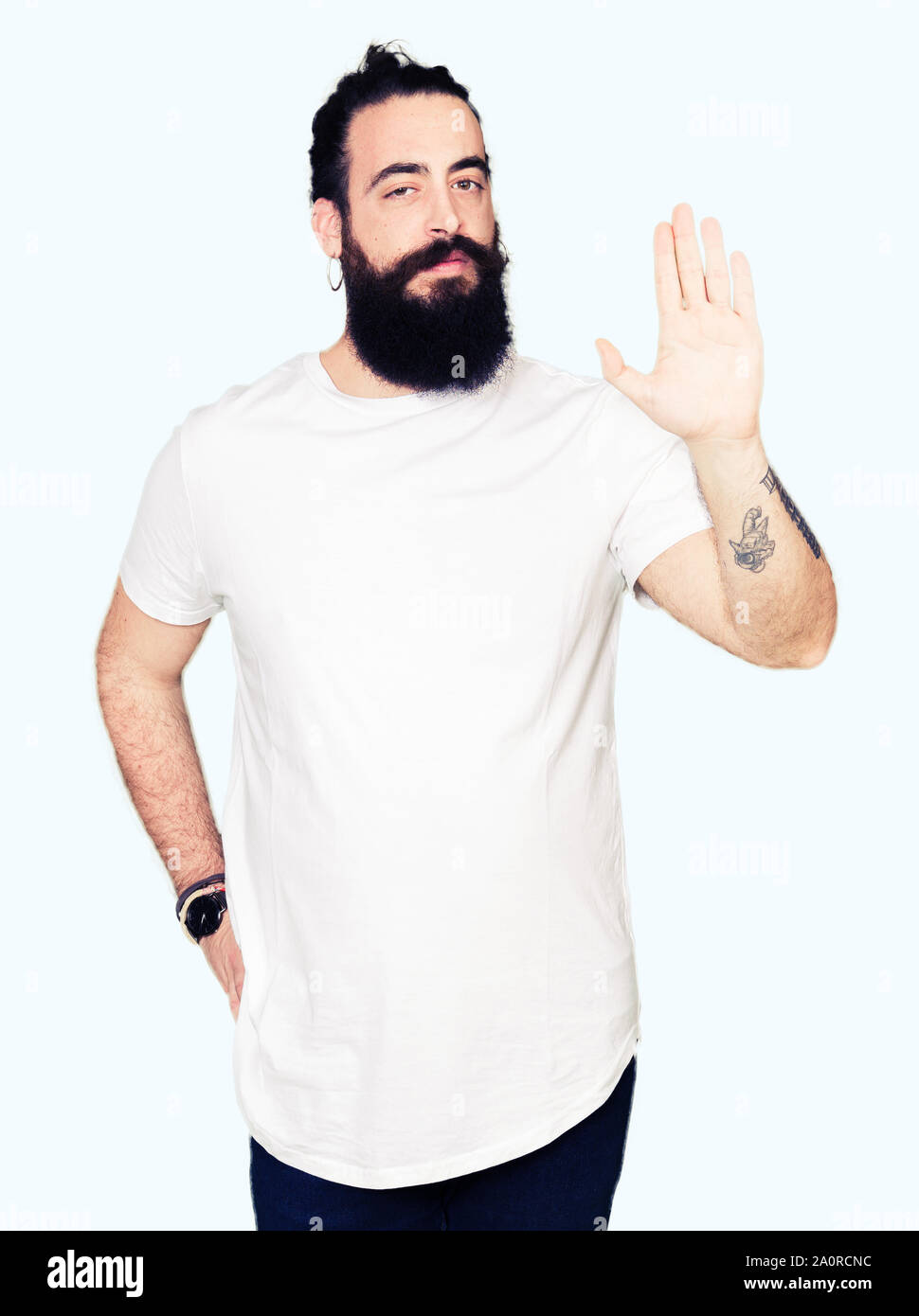 Young hipster man with long hair and beard wearing casual white t-shirt ...