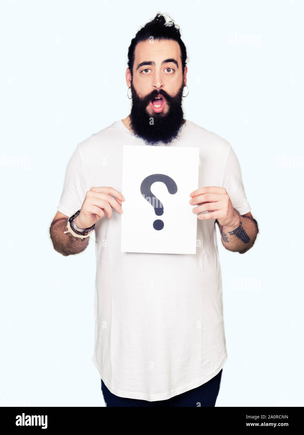 Young man with long hair and bear holding a paper with question mark ...