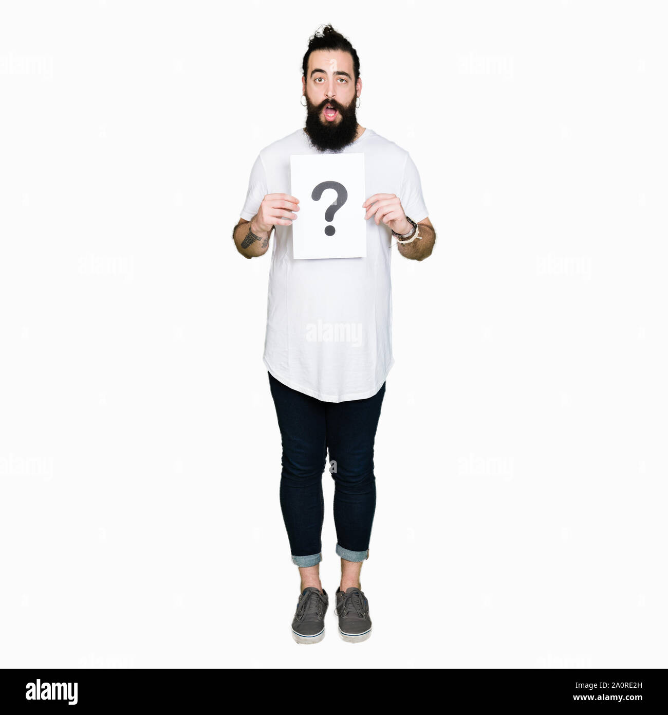 Young man with long hair and bear holding a paper with question mark ...