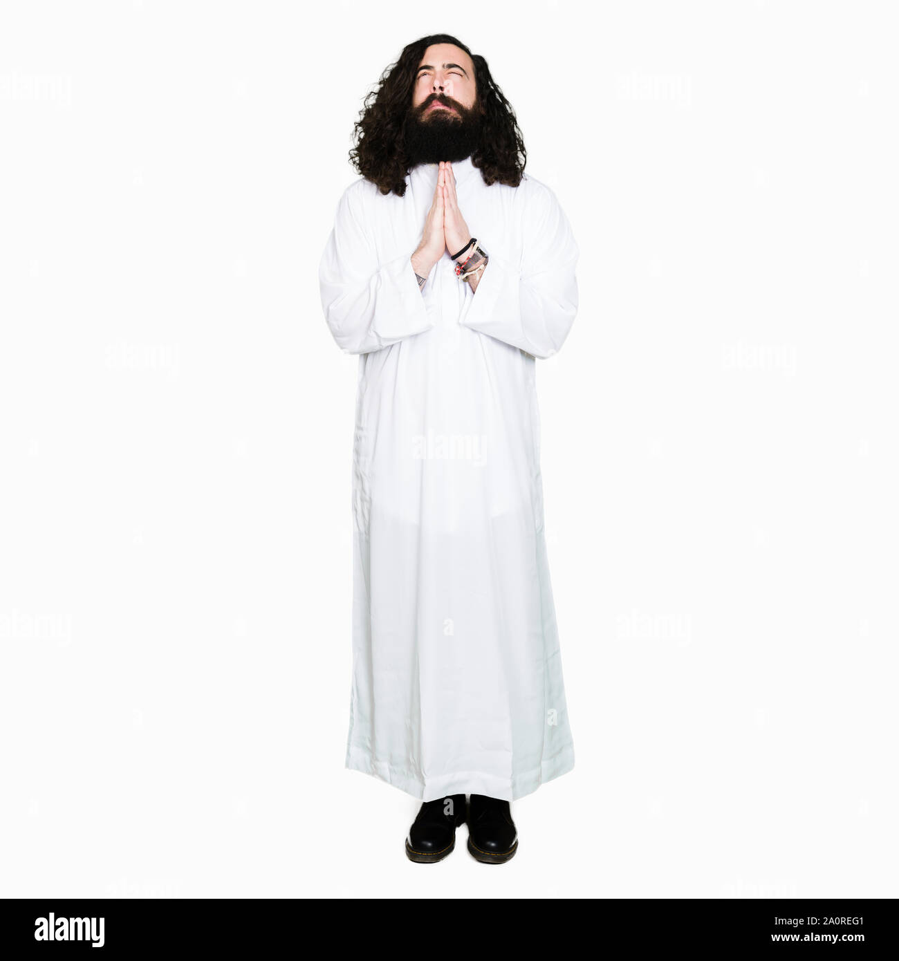 Man wearing Jesus Christ costume begging and praying with hands ...
