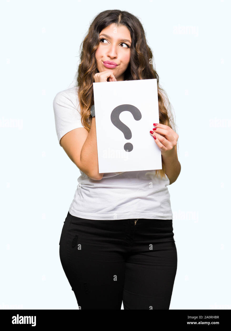 Young adult woman holding paper with question mark serious face ...