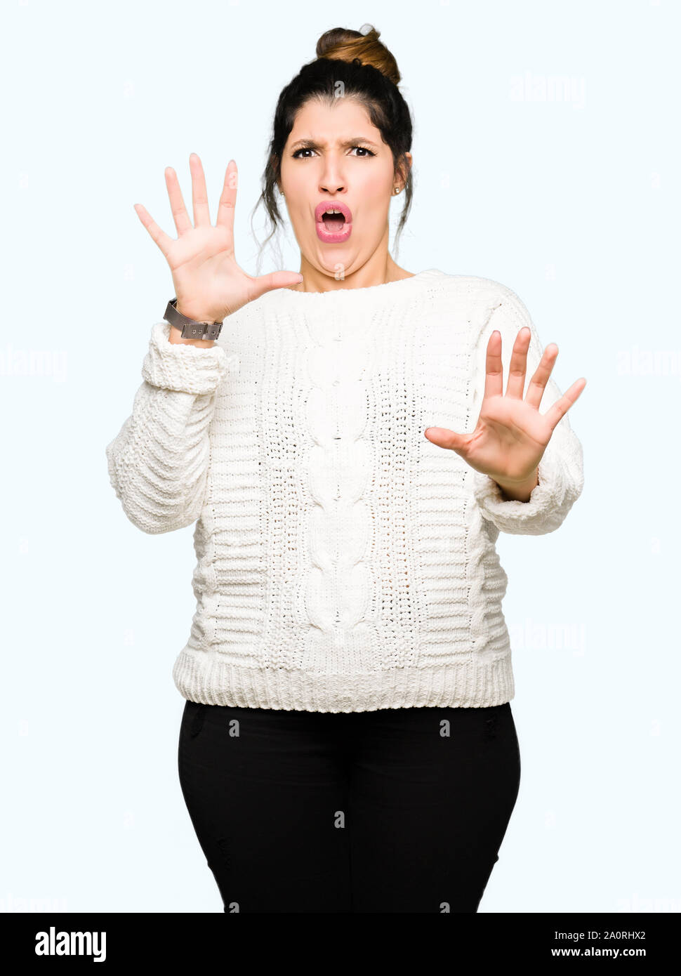 Young beautiful woman wearing winter sweater afraid and terrified with ...