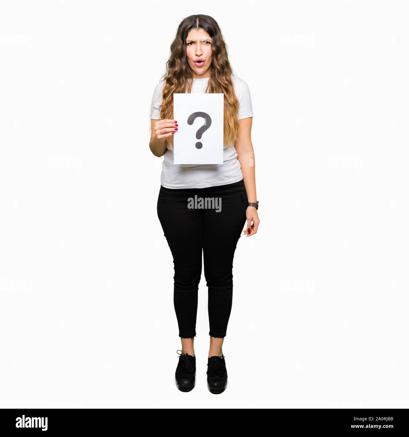 Young adult woman holding paper with question mark scared in shock with ...