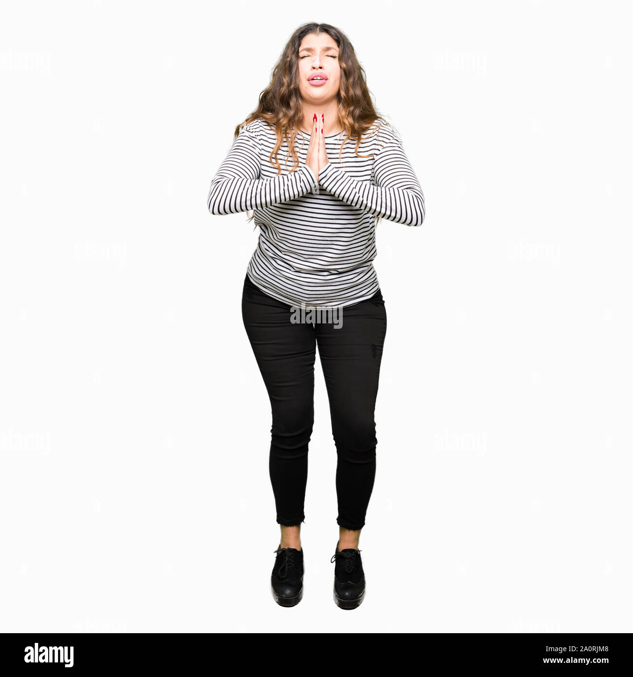 Young beautiful woman wearing stripes sweater begging and praying with ...