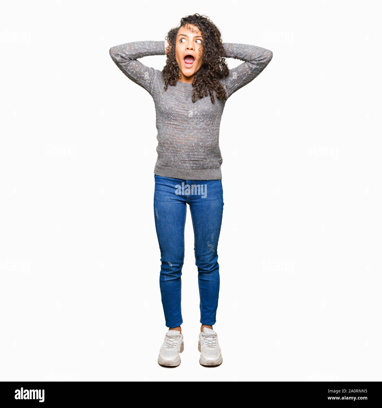 Young beautiful woman with curly hair wearing grey sweater Crazy and ...