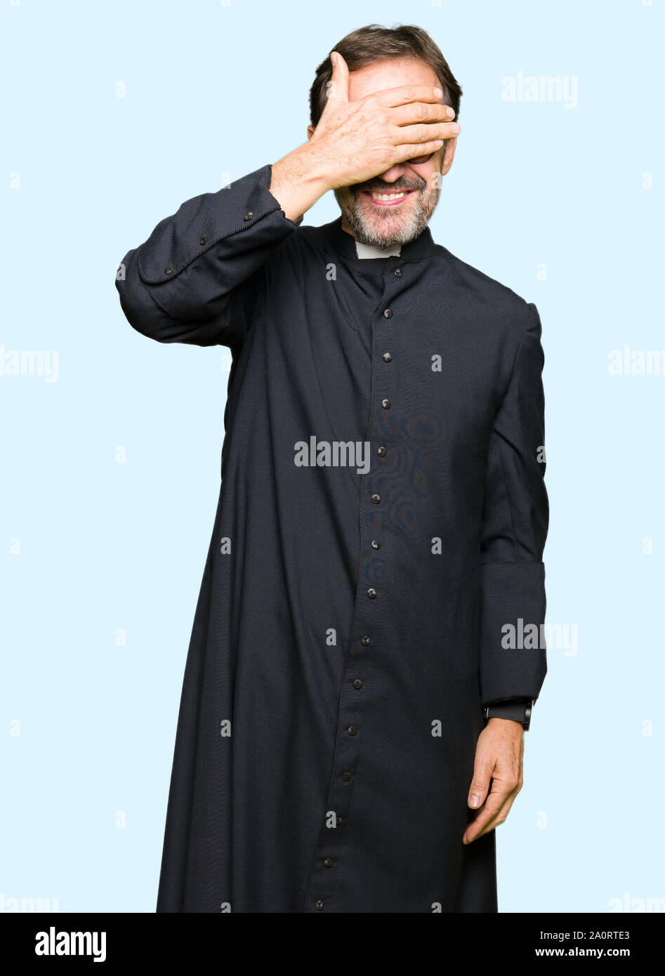 Middle age priest man wearing catholic robe smiling and laughing with ...