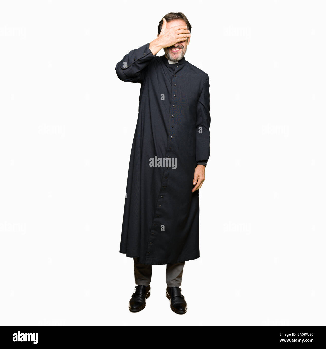 Middle age priest man wearing catholic robe smiling and laughing with ...