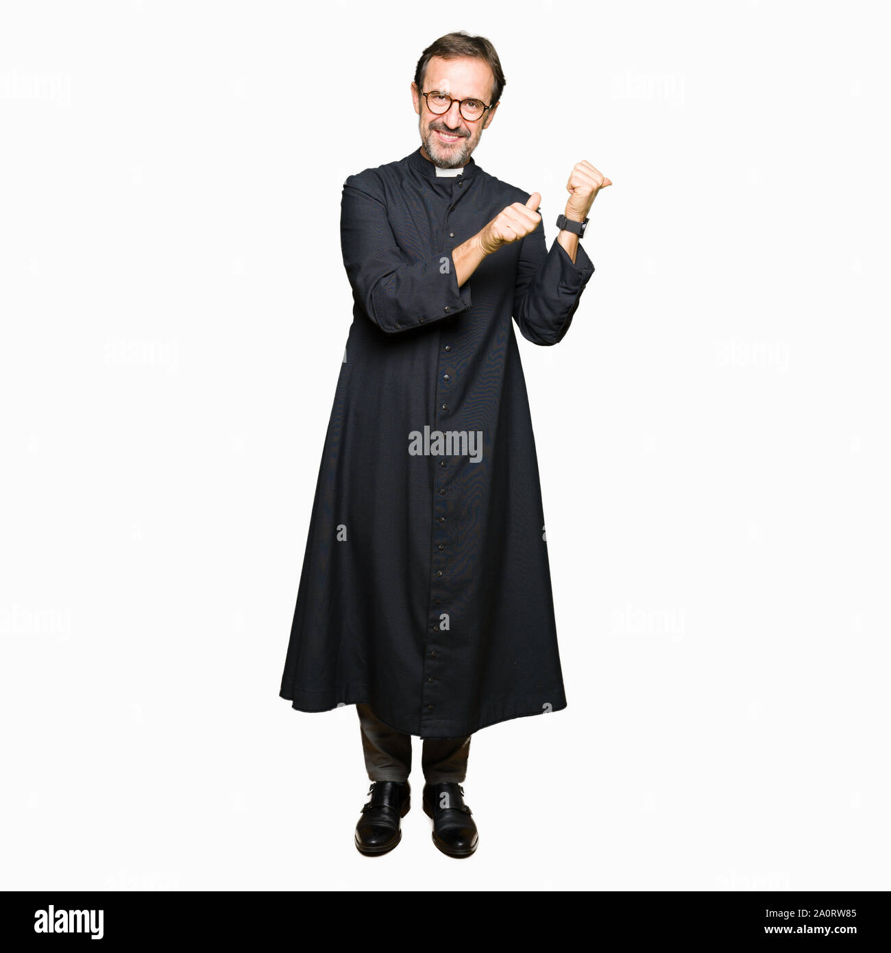 Middle age priest man wearing catholic robe Pointing to the back behind ...