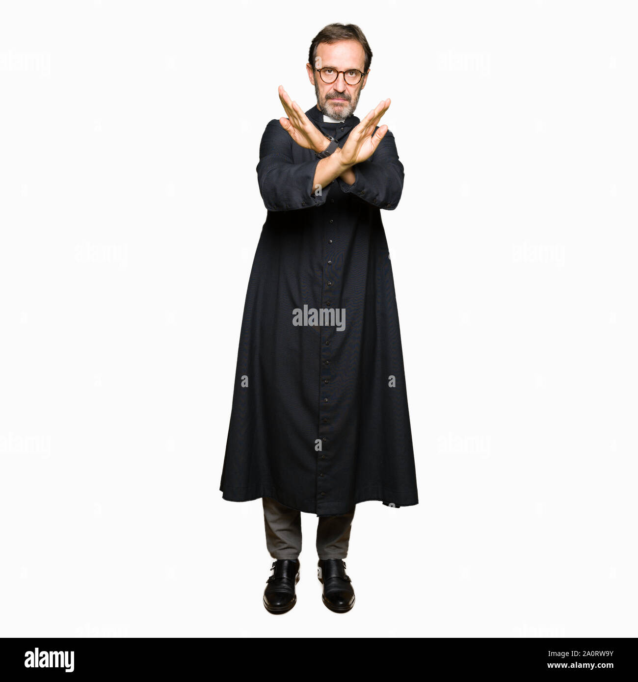Middle age priest man wearing catholic robe Rejection expression ...