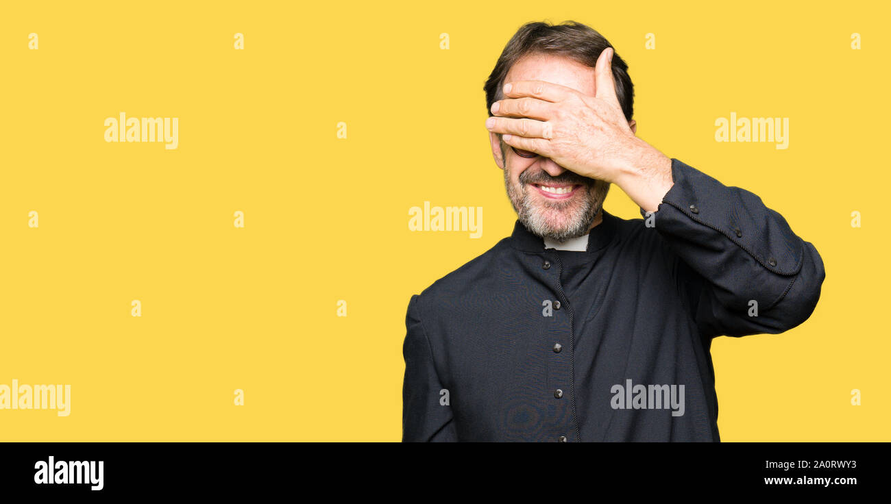 Middle age priest man wearing catholic robe smiling and laughing with ...