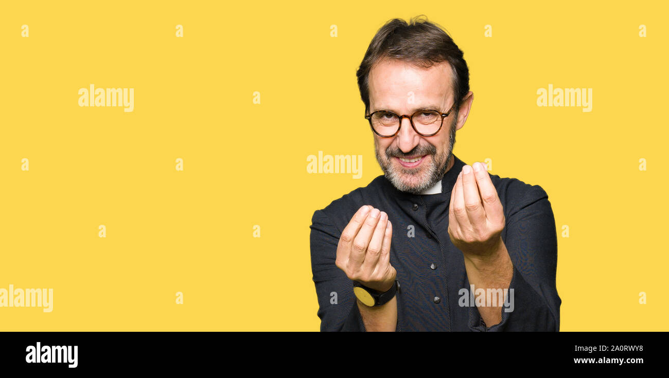 Middle age priest man wearing catholic robe Doing money gesture with ...