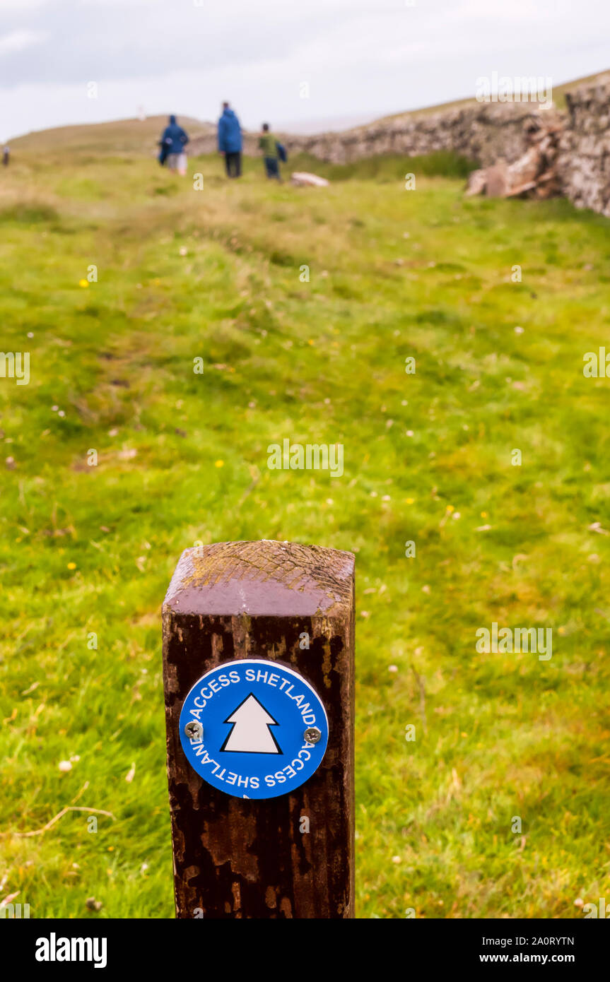 An Access Shetland waymarking sign on the Island of Mousa with walkers ...