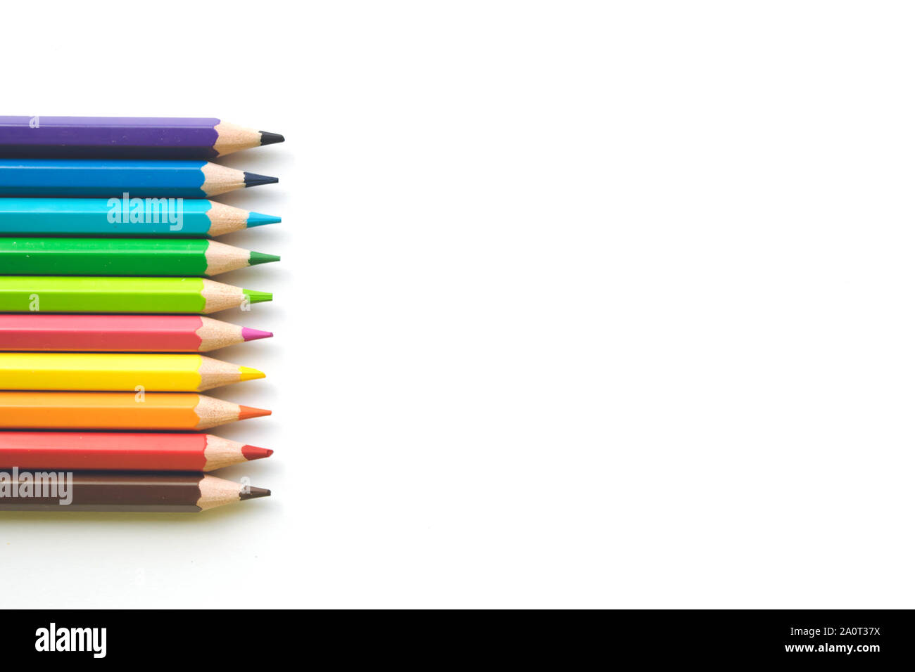 Rows of Color pencils on white paper background, copy space. Office ...