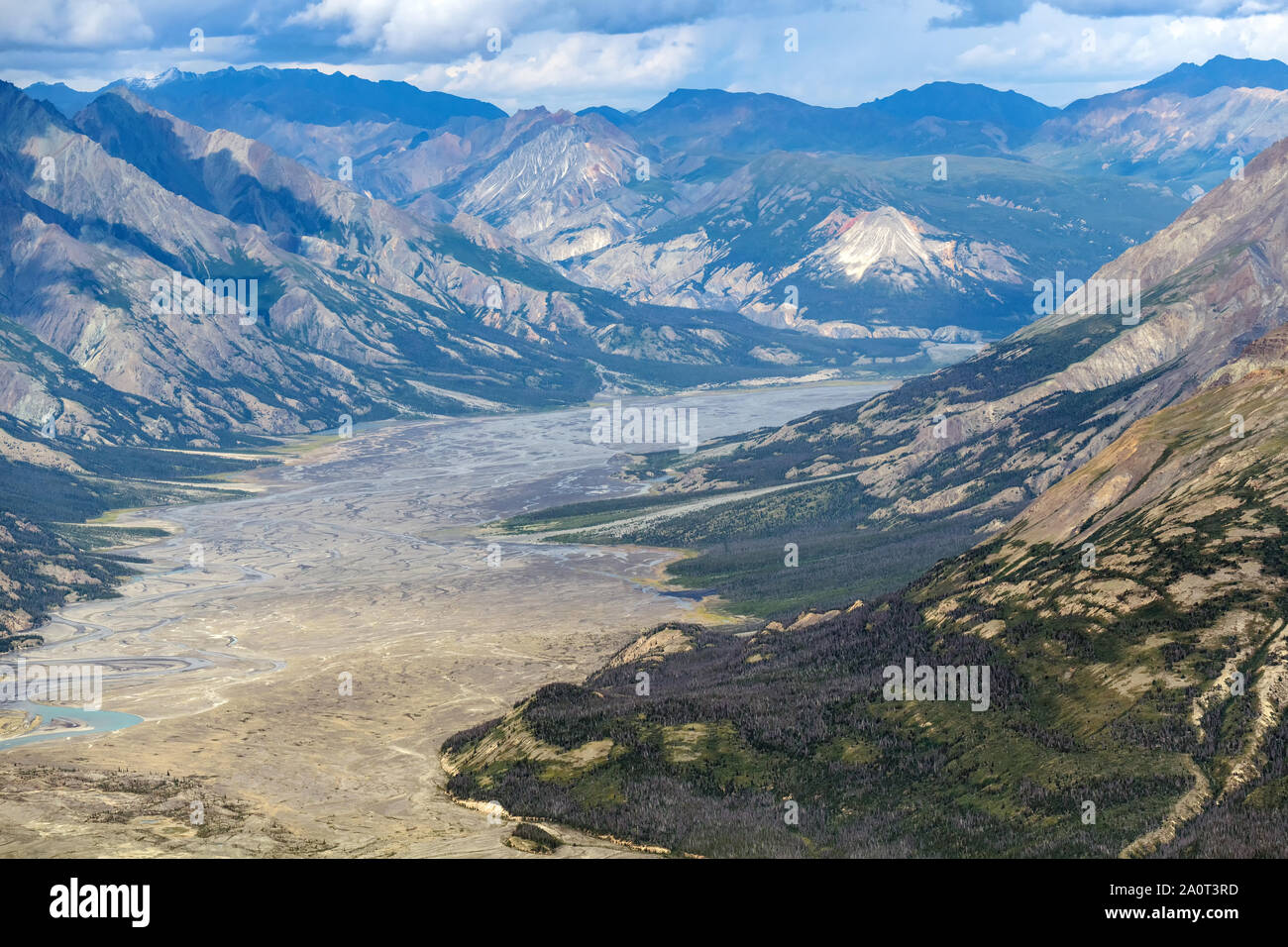 The Kaskawulsh river flows below mountains in Kluane National Park ...