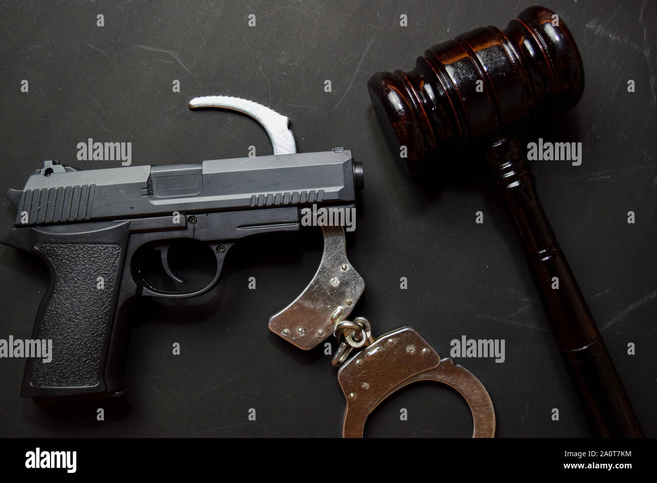 gun, handcuffs and black gavel isolated on black background. Justice ...