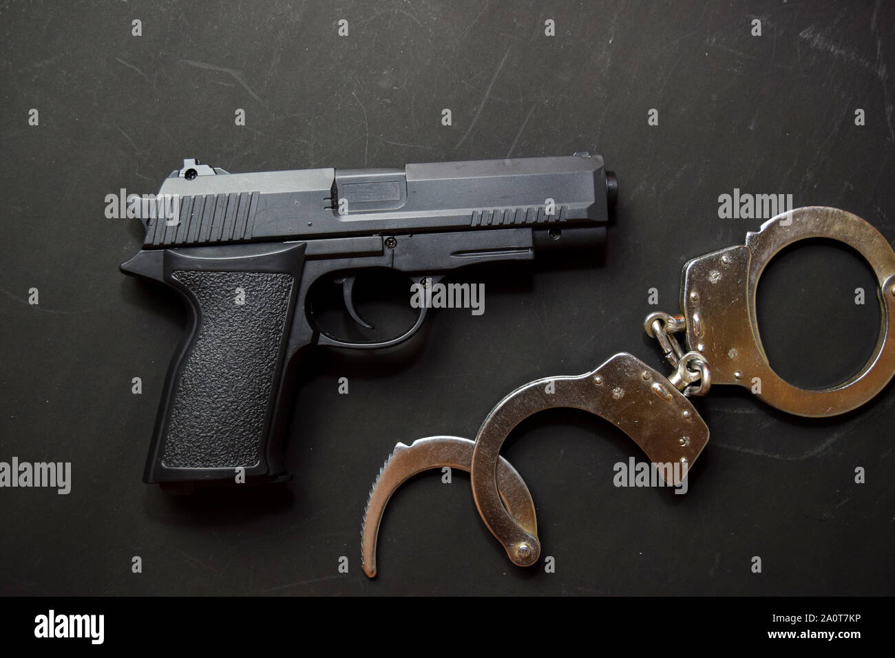 Handcuffs and Gun isolated on black background. Justice and law concept ...
