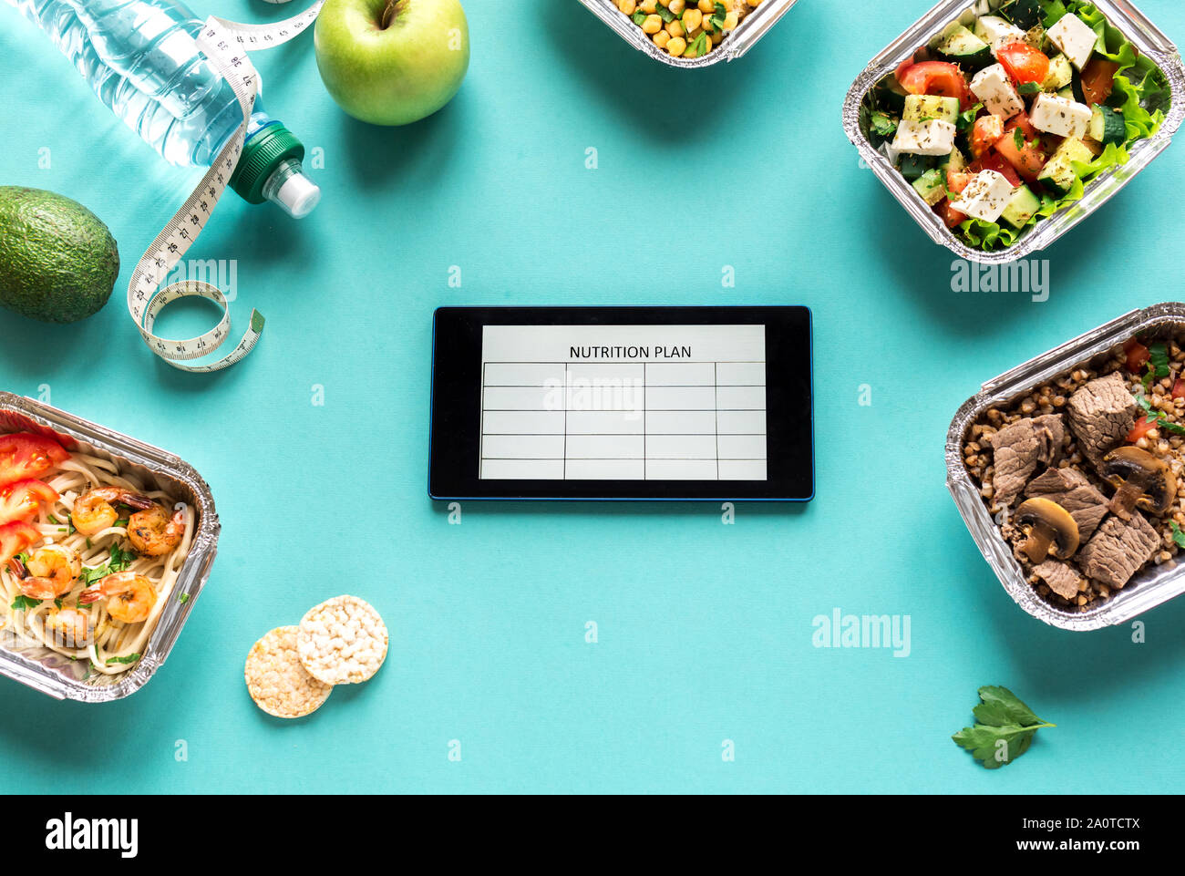 Nutrition plan flat lay with water, fruits, healthy meals and measuring ...