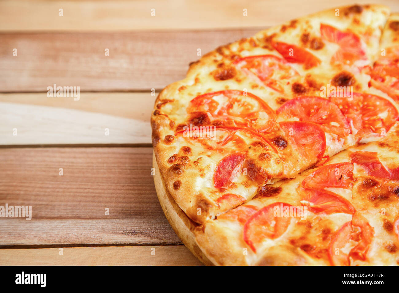 medium-sized pizza with tomatoes on a wooden tray Stock Photo - Alamy