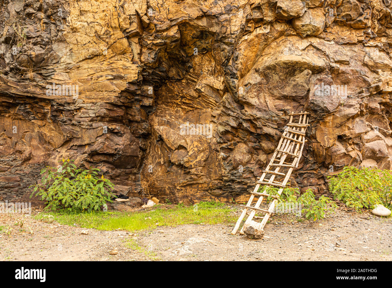 Colour photograph of quarry cliff face with single wood improvised ...