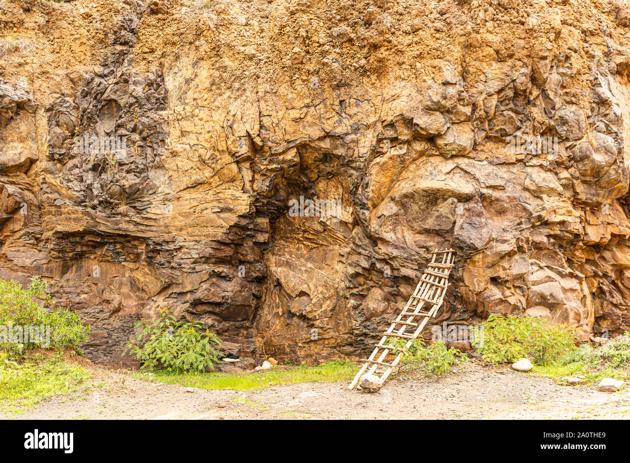 Colour photograph of quarry cliff face with single wood improvised ...