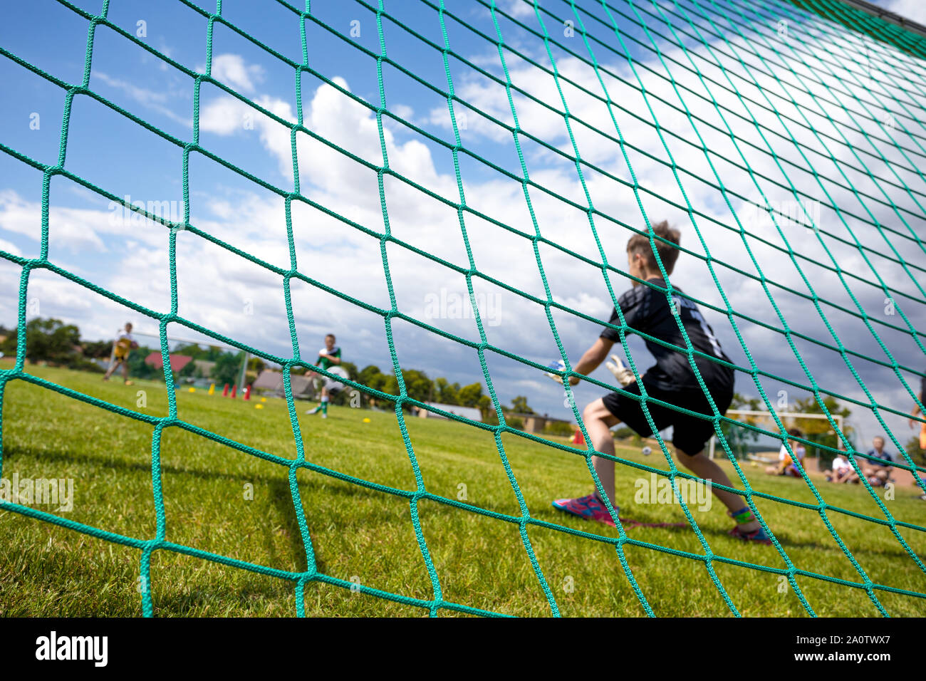 Soccer goal with a young boy goalkeeper. Youth football goalkeeper save ...