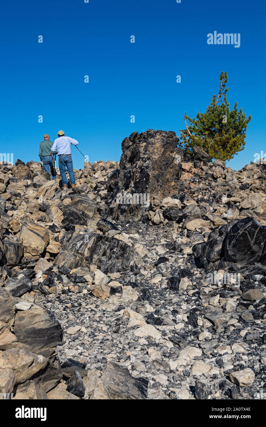 Oregon, Newberry National Volcanic Monument, Big Obsidian Flow Trail, two senior men hiking ...