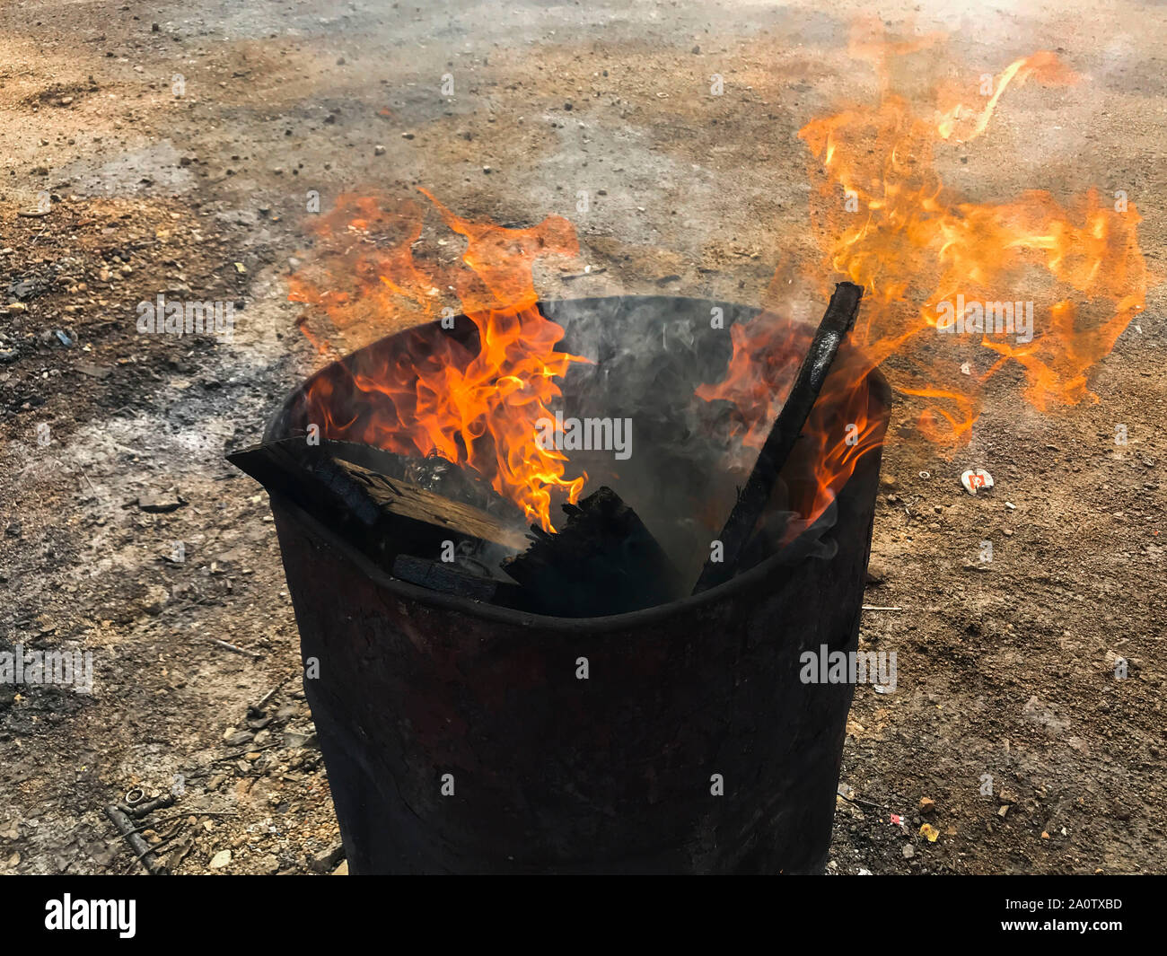 Burning wood fire in oil barrel in industry Stock Photo - Alamy