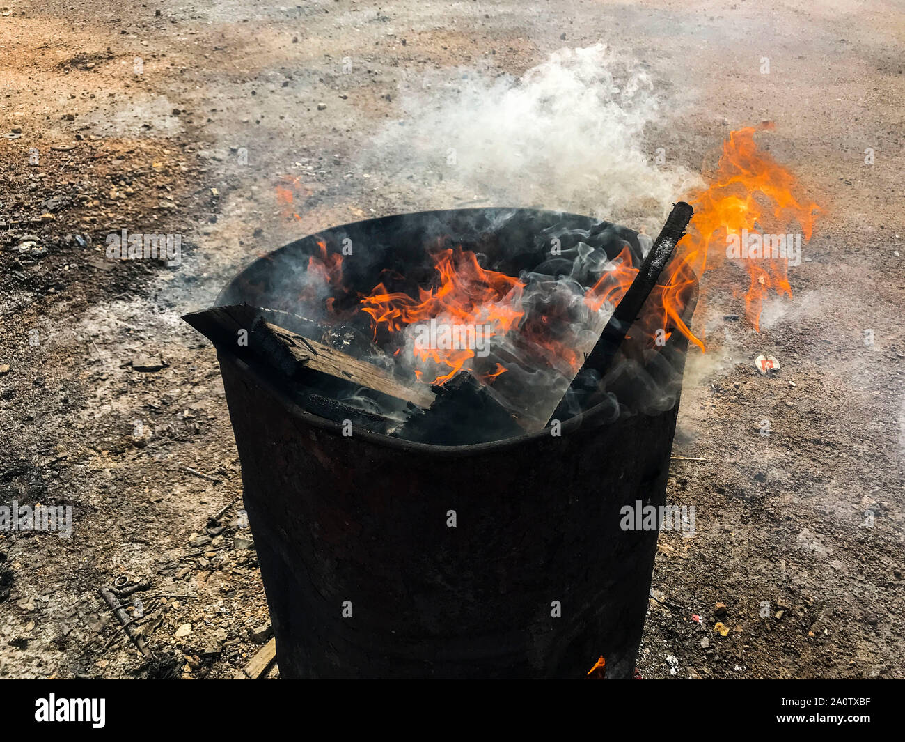 Burning wood fire in oil barrel in industry Stock Photo - Alamy