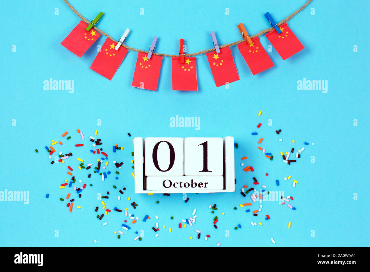 October 1 Wooden calendar, confetti and flag on blue background ...