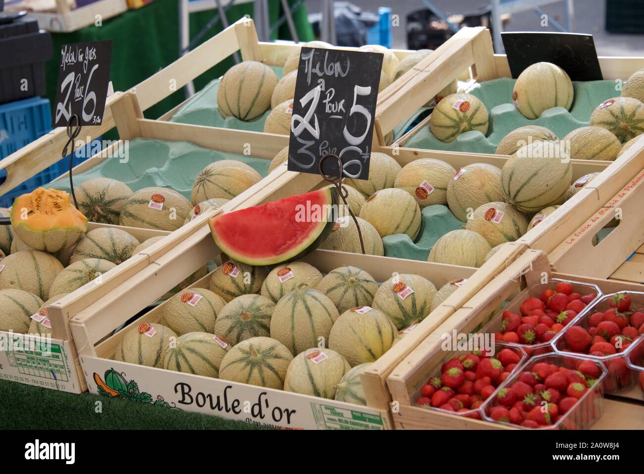 French market stall: Charentais melons and strawberries displayed on a ...
