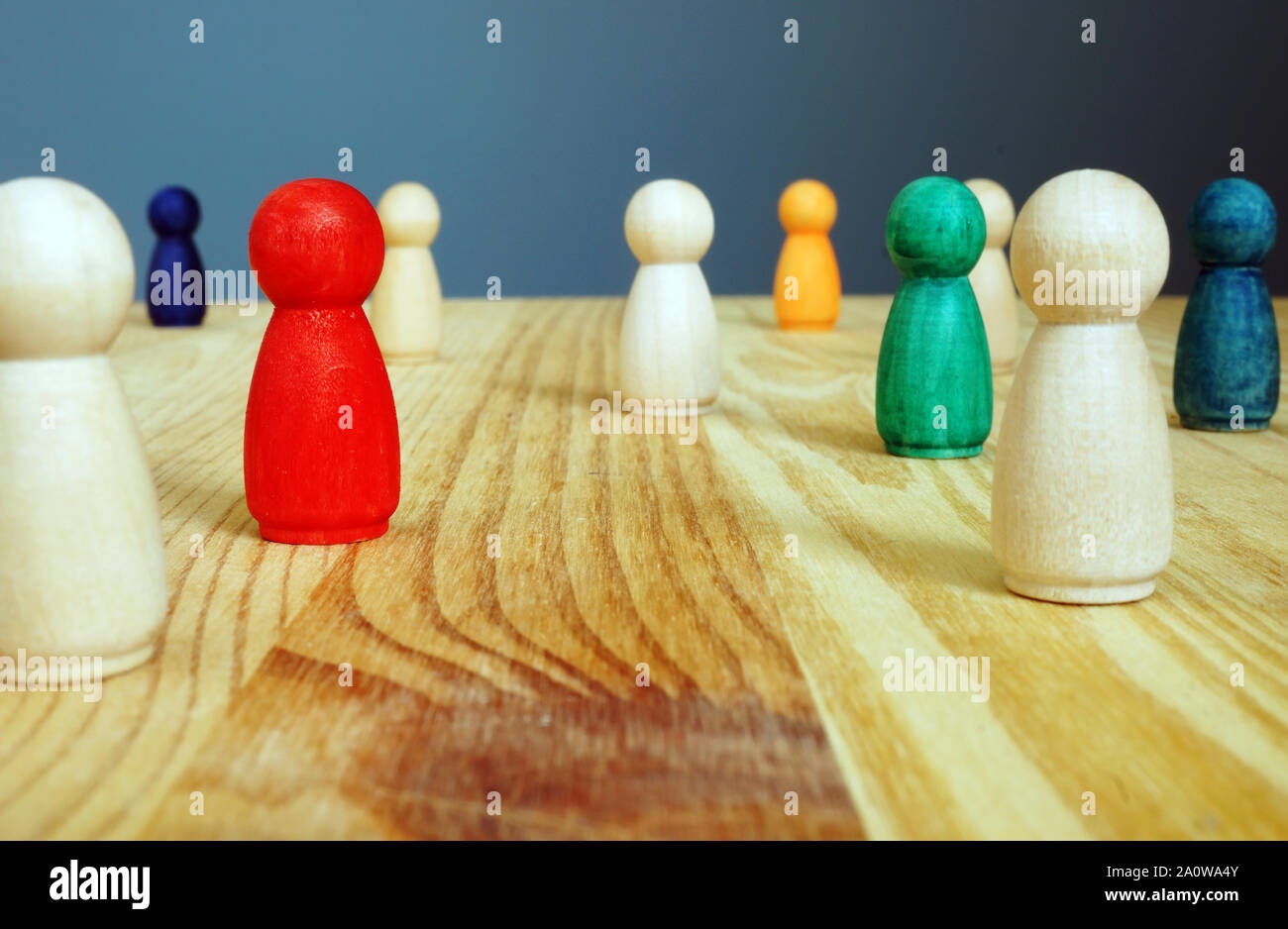 Diversity concept. Colored figures between wooden ones Stock Photo - Alamy