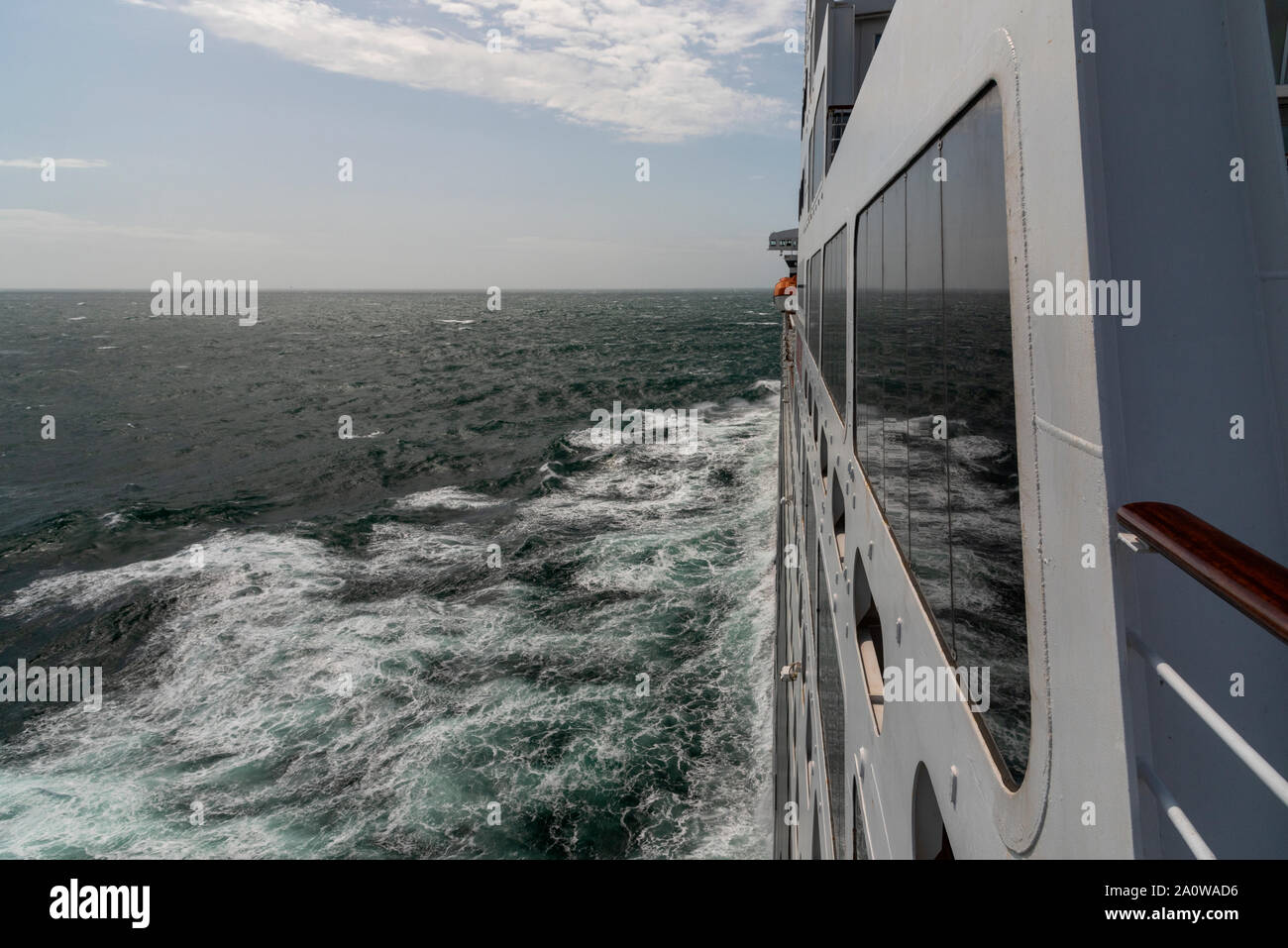 Looking along the side of Queen Mary 2 at black water of the North Sea ...