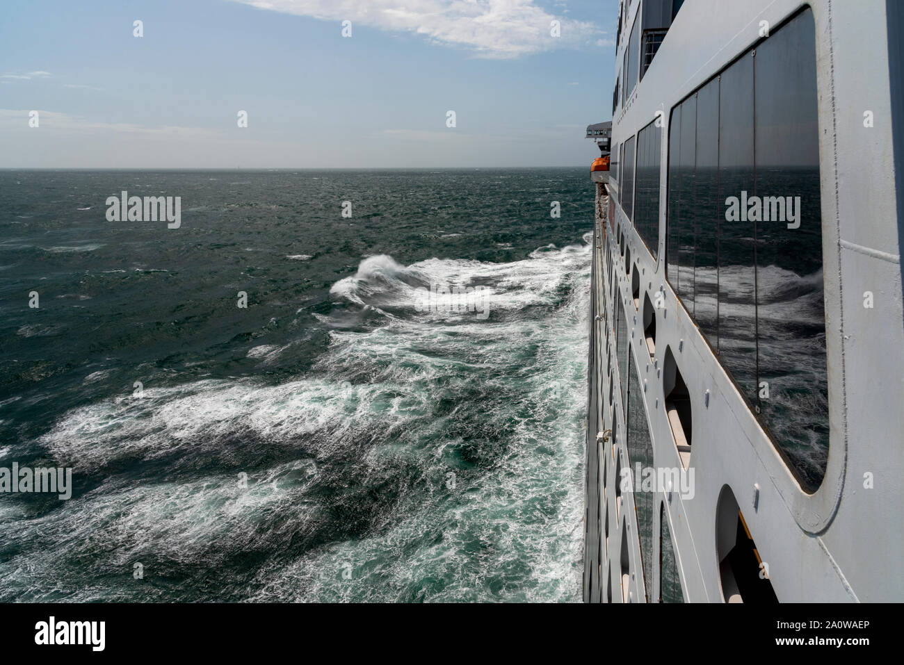 Looking along the side of Queen Mary 2 at black water of the North Sea ...