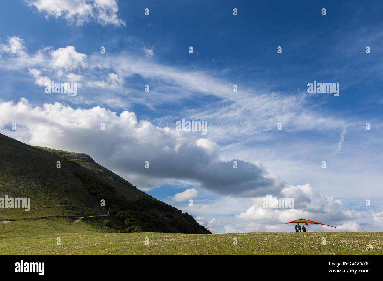 A paraglider on the ground on Mt. Cucco (Umbria, Italy) below a deep ...