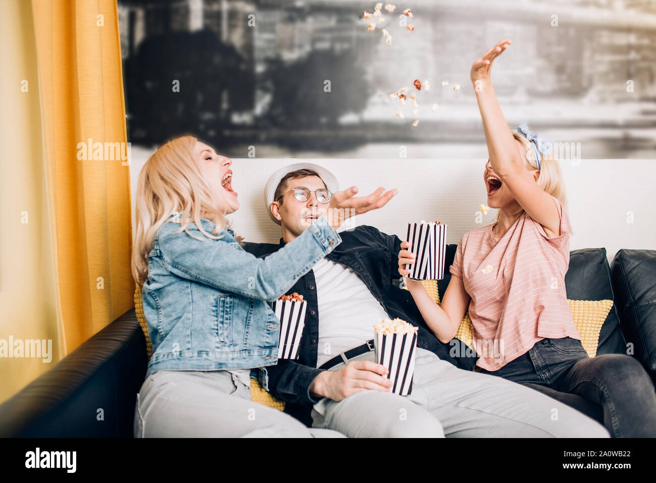 Happy friends relaxing sitting on couch and watching championship or ...