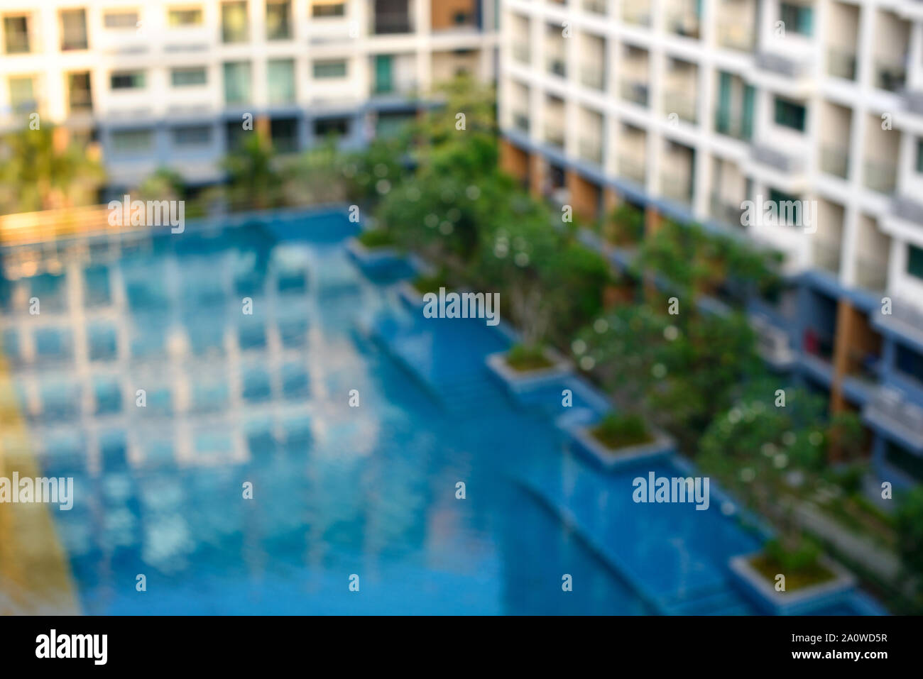 A resort swimming pool view from above. Reflection on water. Defocused ...
