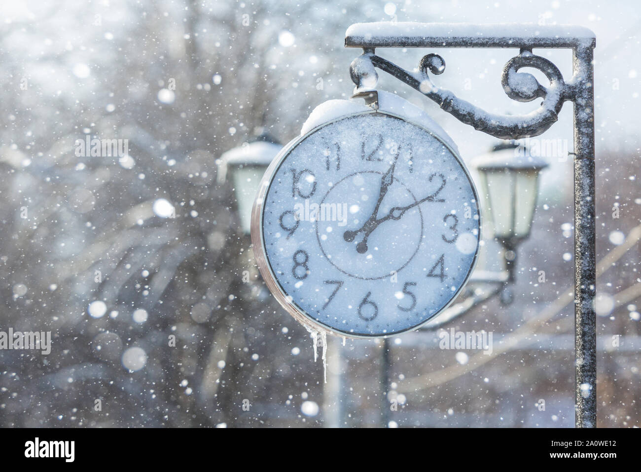The clock on the street. Winter snowfall. Hours are covered with ice ...