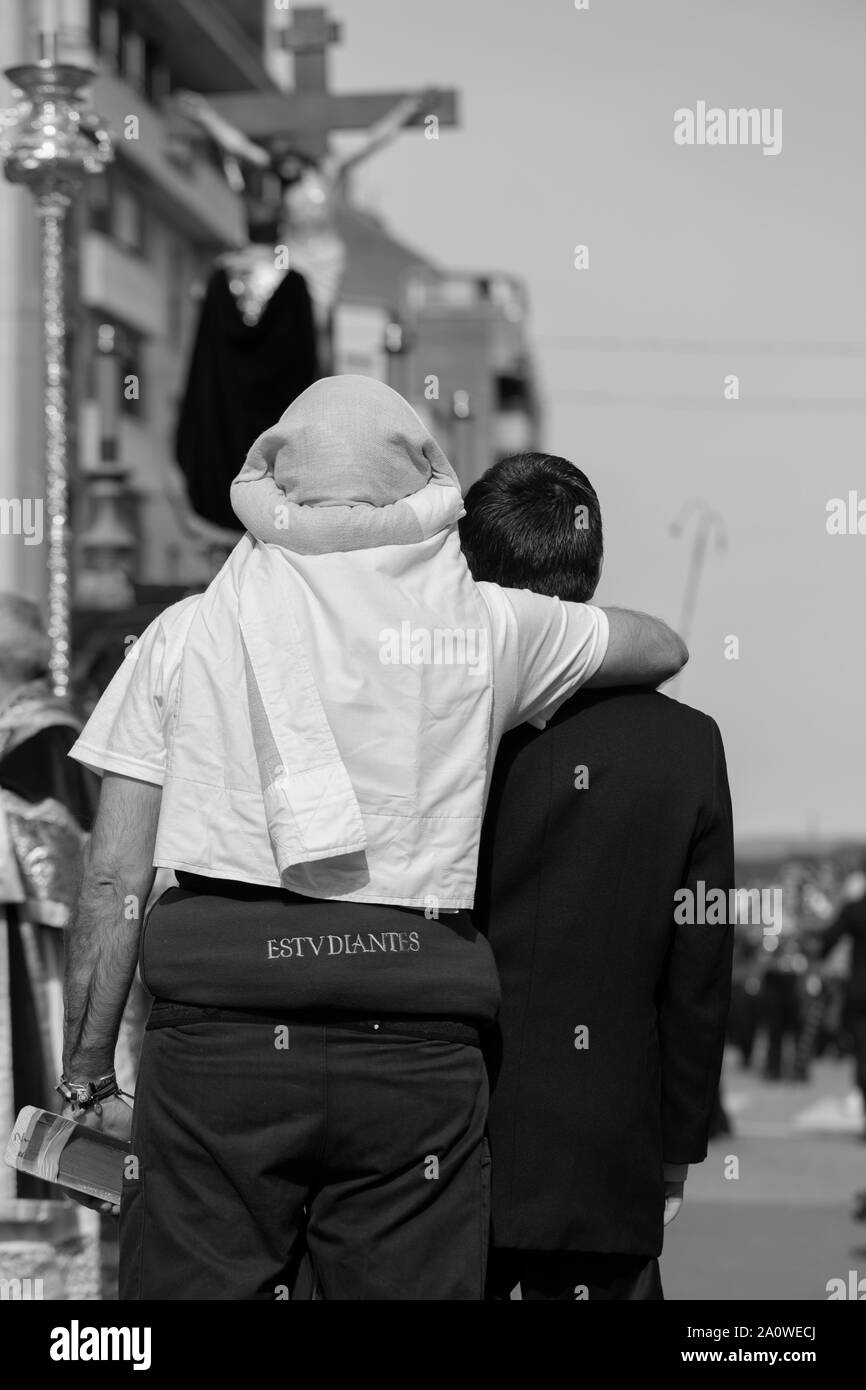 Two men embraced in front of a crucifix Stock Photo - Alamy