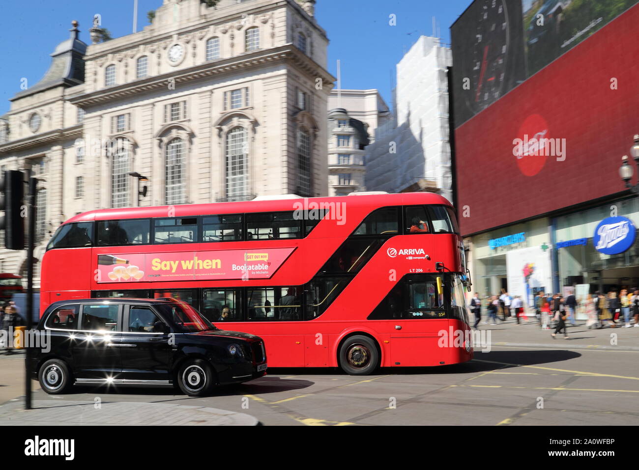 A red London Double-Decker Bus and a black cab at Piccadilly Circus ...