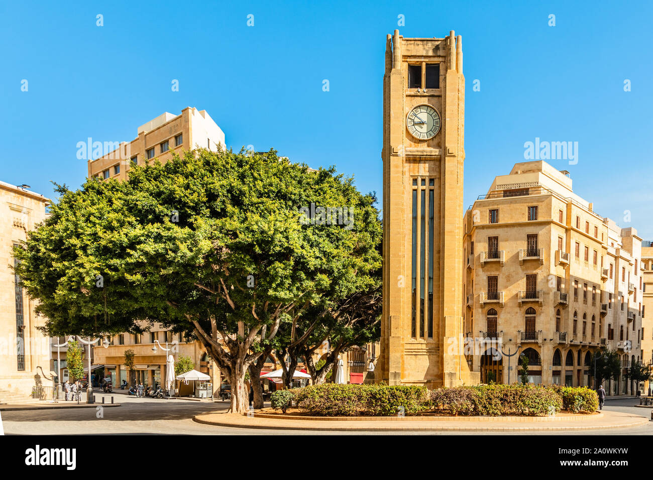 Al-Abed Nejmeh Square clock tower with tree and buildings around ...
