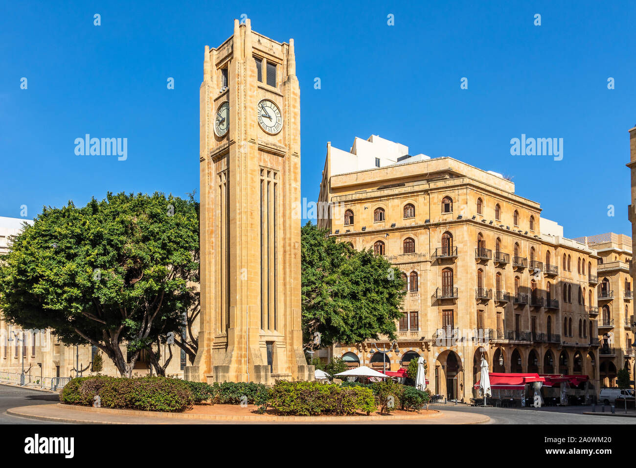 Al-Abed Nejmeh Square clock tower with tree and buildings around ...
