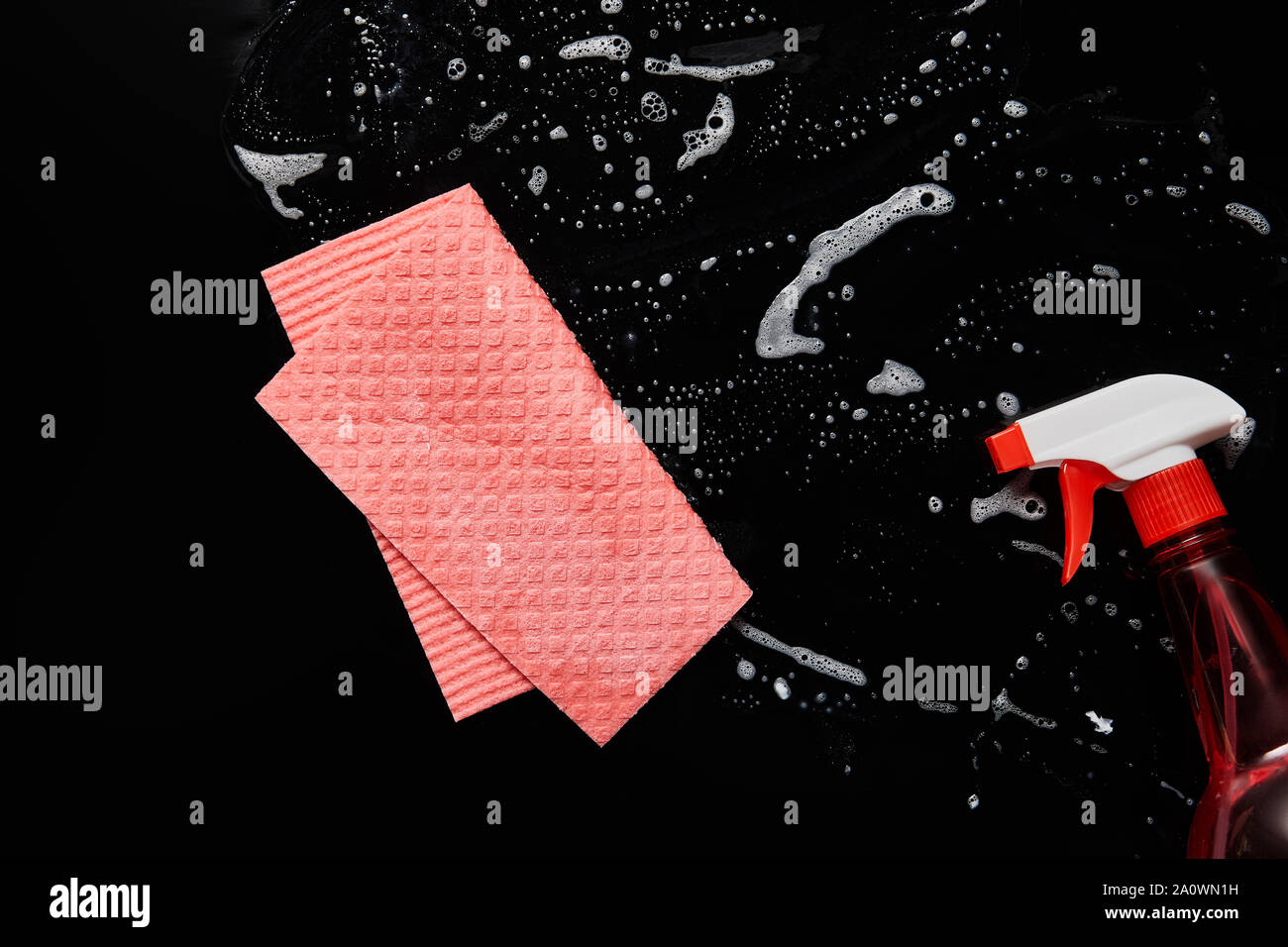 top view of pink rag and bottle with spray on black background Stock ...