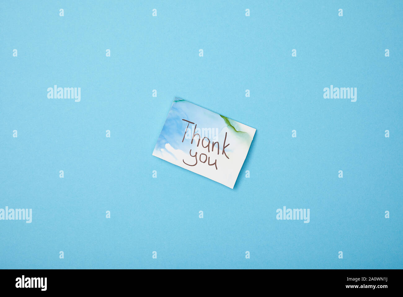 greeting card with thank you lettering on blue background with copy ...