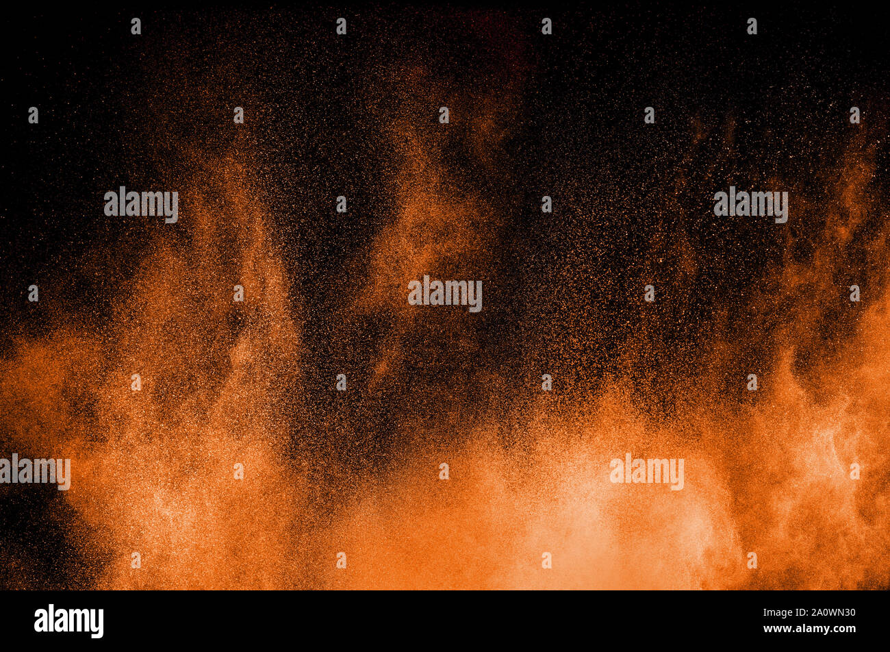 Orange powder explosion on black background. Orange color dust splash ...