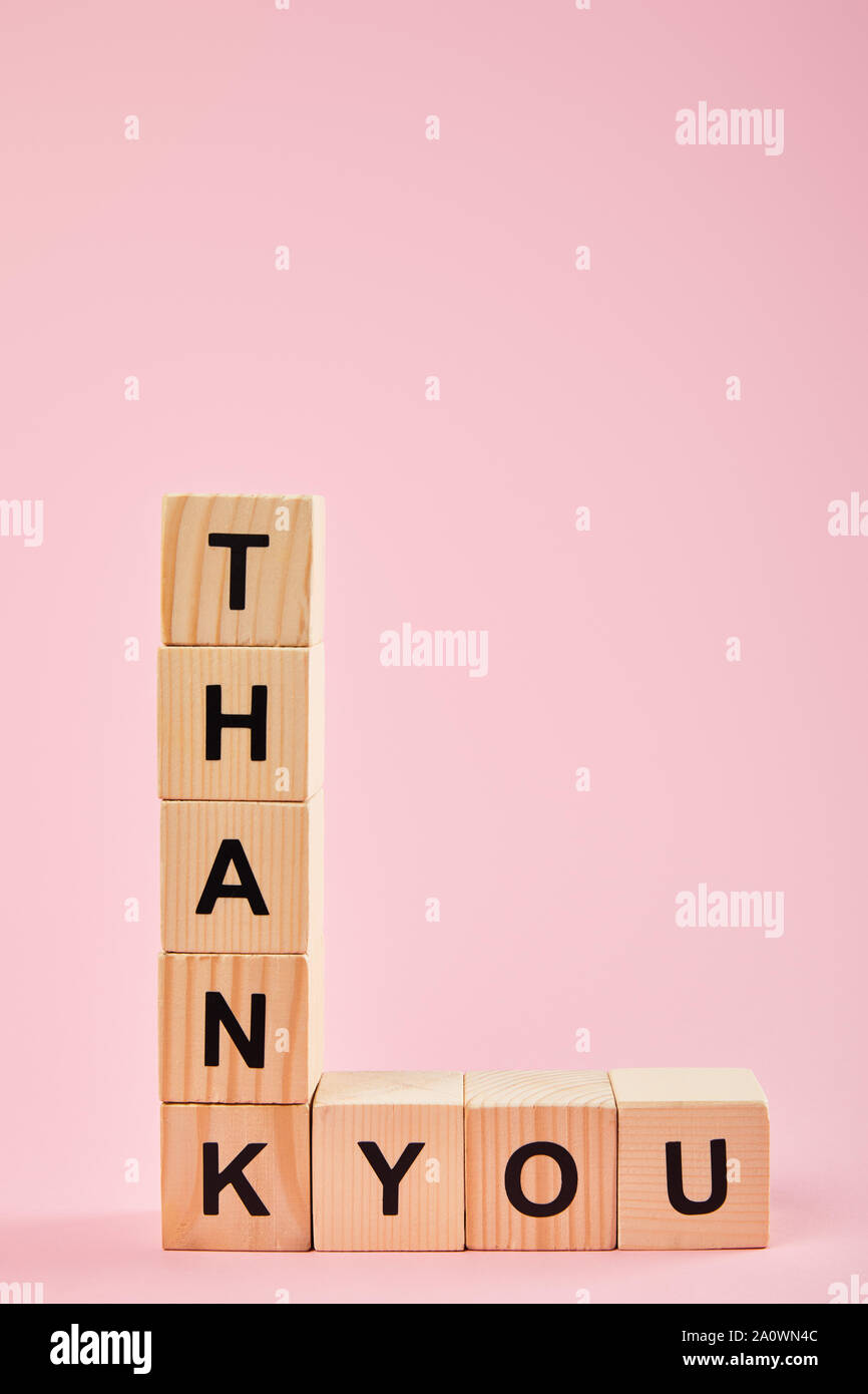 wooden cubes with thank you lettering on pink background with copy ...